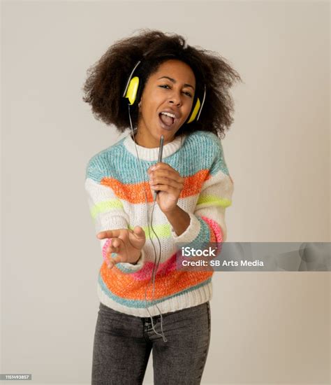화려하 고 행복 한 아프리카계 미국인 여자의 쿨 초상화 노래와 중립 배경에서 춤을 헤드폰에서 스마트 폰 음악 응용 프로그램을 듣고 사람들의 음악 기술과 행복 관능에 대한