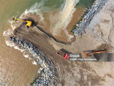 모래 트럭이 있는 굴착기는 해변 강 또는 댐에서 작업하며 드론에서 볼 수 있습니다 댐에 대한 스톡 사진 및 기타 이미지 댐