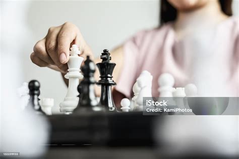 체스판에 흰색 체스 조각을 들고 있는 사업가가 체스판을 경영행정과 비교하고 목표를 달성하고 문제 해결을 위한 작업을 계획합니다 비즈니스 관리 개념 개념에 대한 스톡 사진 및