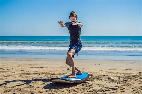 젊은 서퍼는 모래 해변에 라인업에 이동 하기 전에 훈련 남자 서핑을 학습 휴가 개념 여름 휴일입니다 관광 스포츠 균형에 대한
