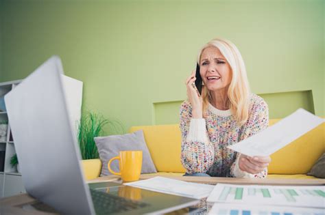 예쁜 나이 든 여자 말하기 전화 사용 노트북 사용 문서 거실 아파트 실내의 사진 50 54세에 대한 스톡 사진 및 기타 이미지 Istock