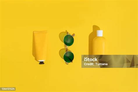 자외선 차단제 녹색 선글라스가있는 튜브와 병으로 다채로운 배경에 여름 밝은 평탄색 하드 그림자와 빛 맨 위 보기입니다 플랫 레이 트렌드 스타일 복사 공간을 참조하십시오 0