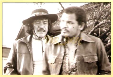 An Old Black And White Photo Of Two Men Standing Next To Each Other In