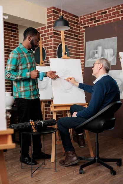 미술 수업에 참석하는 시니어 남자가 그림 수업 중에 다른 학생과 교사들과 상호 작용하고 은퇴 후 새로운 것을 배우는 사람들 무료 사진