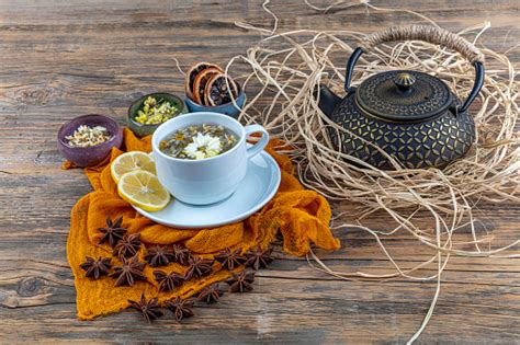 주전자에 카모마일 차 카모마일 티 컵 골동품 중국 주철 주전자 레몬과 나무 테이블에 스타 아니스 감귤류 과일에 대한 스톡 사진