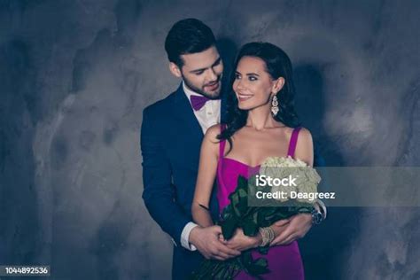 서로 보고 회색 배경에 고립 된 보라색 드레스에 턱시도 Bowtie 손 사랑 스러운 로맨틱 배우자에에서 하얀 장미를 들고와 보석 신사 숙 녀의 초상화 2명에 대한 스톡 사진