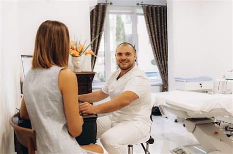 병원 내 진료실에서 쾌활하고 친절한 남성 의사 노트북 모니터 화면에 검사 결과를 보여주고 진료실에 앉아있는 젊은 여성 환자와 상담을합니다 25 29세에 대한 스톡 사진 및