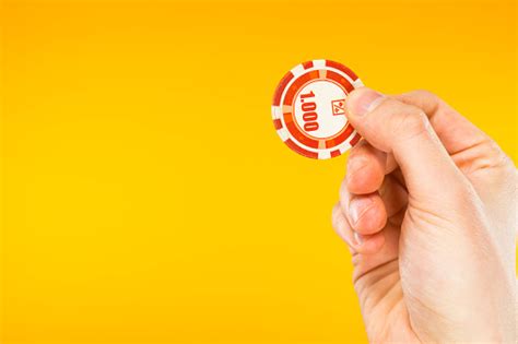 텍스트 에 대한 여유 공간이있는 밝은 노란색 배경 클로즈업에 카지노 포커 칩을 들고있는 손 20 24세에 대한 스톡 사진 및 기타 이미지 20 24세 Brand