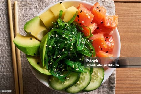 연어 아보카도 쌀 華 샐러드 치즈 메 추 라 기 계란 간장 나무 배경 평면도 클로즈업에 리넨 냅킨 식탁보와 젓가락 흰색과 검은 참 깨 뿌리고와 그릇 0명에 대한 스톡 사진