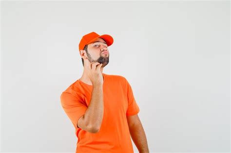 Free Photo Delivery Man Checking Face Skin By Touching His Beard In