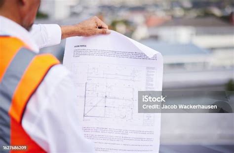 건설 현장 청사진 그리고 뒤에서 도시의 건축 제안서 문서를 읽는 남자 토목 공학의 산업 발전을 위한 평면도 프로젝트 또는 건축의 근접 설계 50 54세에 대한 스톡 사진 및
