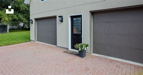 두 개의 차고 문과 화분이있는 집 사진 Unsplash의 무료 부동산 이미지