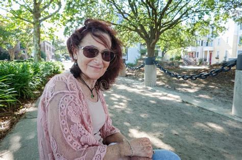 Pretty Senior Citizen Woman Wearing Shawl And Sunglasses Sitting In A
