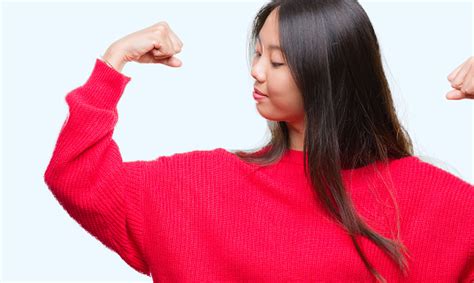 젊은 아시아 여성 이상의 겨울 스웨터를 입고 미소를 자랑 하는 팔 근육을 보여주는 배경 고립 피트 니스 개념입니다 가을에 대한 스톡 사진 및 기타 이미지 Istock