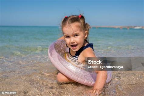 화창한 날에 바다에서 수영하는 법을 배우는 풍선 반지와 귀여운 어린이 소녀의 초상화 아이들을위한 재미있는 물 장난감 해변 개념에 가족 여름 휴가 2 3 살에 대한 스톡 사진