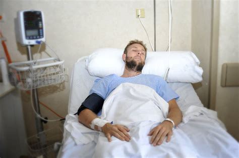 Раненый человек лежа в палате кровати отдыхая от боли смотря в плохом состоянии здоровья