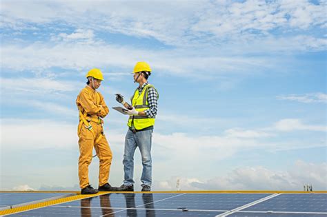 엔지니어는 공장 지붕에 태양 전지판 설치를 확인하고 엔지니어에게 명령을 내리고 태양 전지판 설치를 감독하고 엔지니어와 기술자는 태양 전지판의 작동을 확인합니다 20 24세에