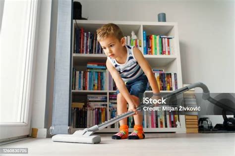 집에서 진공 청소기를 사용하여 작은 아이 아파트에서 작은 소년 청소 바닥 아이가 재미가 있는 가사를하고 여름날에 전체 길이를 볼 수 있습니다 어린 시절 개발 실제 사람들