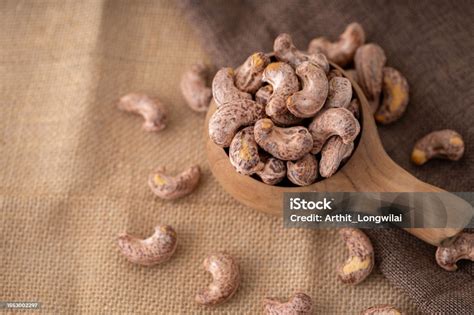 구운 캐슈넛과 반쪽을 테이블 위에 있는 나무 그릇에 담았다 매크로 스튜디오 샷 바구니에 담긴 수제 구운 소금에 절인 캐슈넛과 자루에 담긴 아침 식사 건강 식품 씨앗 스낵