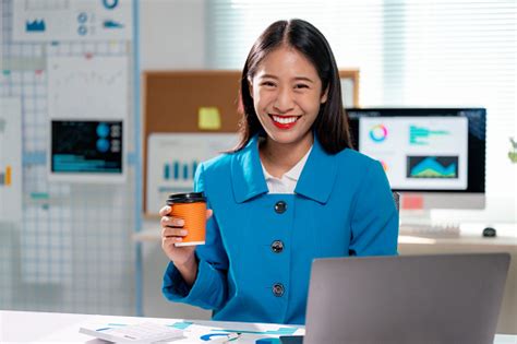 커피를 마시는 전문직 아시아 여성 현대 사무실에서 노트북으로 작업 화면에 보이는 데이터 차트와 함께 자신 있게 미소 짓는 20 29세에 대한 스톡 사진 및 기타 이미지