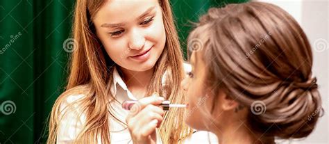 Makeup In The Process The Makeup Artist Applies Pink Gloss Lipstick On