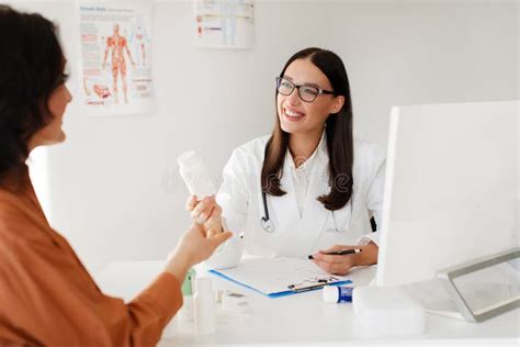 Drug Prescribing Positive Doctor Woman Giving Jar Of Pills To Patient