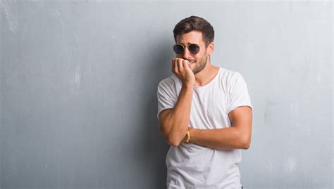 강조 하 고 손톱을 물어 뜯고 입에 손을 긴장을 찾고 선글라스 입고 회색 그런 지 벽에 잘생긴 젊은 남자 불안 문제입니다 감정에 대한 스톡 사진 및 기타 이미지 Istock