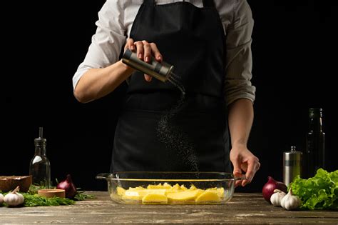 요리사는 야채 소금 뿌리 굽기 전에 감자를 준비 합니다 가로 사진입니다 검은 배경 메뉴 컨셉 요리 건강 한 식습관에 대 한 깨끗