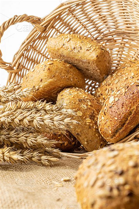 烤面包。用硬面包和面包屑做的黑麦面包。新鲜的乡村传统面包与小麦穗或穗植物在自然棉花背景。烘焙产品标签