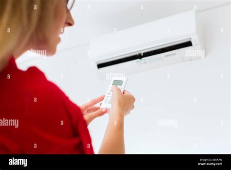 Woman Using Air Condition With Remote Control Stock Photo Alamy