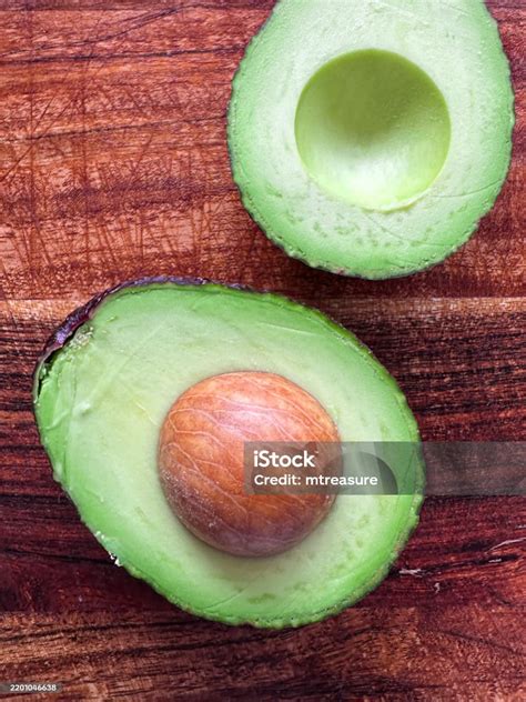 반으로 자른 아보카도 열매의 클로즈업 이미지 큰 씨앗을 표시하는 단면 나뭇결 배경 높은 전망 0명에 대한 스톡 사진 및 기타 이미지 Istock