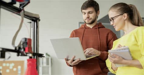 노트북을 들고 프레젠테이션을 하는 젊은 엔지니어와 작업 회의에서 새로운 아이디어를 적는 예쁜 동료 사진 Unsplash의 매니저 이미지