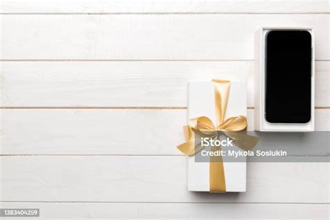 골드 리본과 스마트폰이 있는 기프트 박스를 컬러 배경 상단 보기로 오픈했습니다 빈 오픈 박스 포장 모형 디자인템플릿 브랜딩 모형 Brand Name Smart Phone에