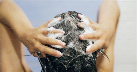 샴푸로 머리를 씻는 젊은 행복한 여자 거품 근접 촬영으로 손 샤워를 하고 휴식 시간을 즐기는 아름다운 갈색 머리 소녀의 뒤 몸과 모발 위생 라이프 스타일 개념 사진