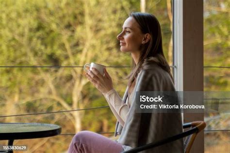 커피 한 잔을 들고 테라스에 있는 여자 격자 무늬를 가진 여자 여름 편안한 라이프 스타일 소박한 라이프 스타일 30 34세에 대한 스톡 사진 및 기타 이미지 Istock