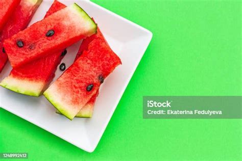 여름 창조적 인 수박 레이아웃 녹색 배경에 흰색 접시에 잘 익은 수박의 달콤한 빨간 조각 건강한 음식 여름 개념 맨 위 보기입니다 공간을 복사합니다 건강한 생활방식에 대한