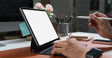 스타일러스 펜을 들고 컴퓨터 태블릿에서 작업하는 스마트 시계를 가진 사업가의 손을 닫습니다 사진 Unsplash의 테이블 이미지