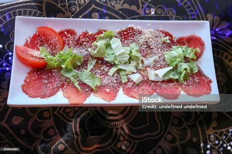 붉은 쇠고기와 돼지고기는 카페 테이블에 흰색 사각형 접시에 채소와 치즈 뿌리고 토마토와의 카르파치오 레스토랑 0명에 대한 스톡 사진 및 기타 이미지 Istock