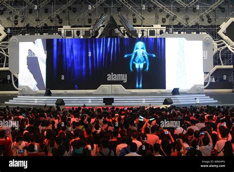 A Crowd Of Visitors Watch A Performance Of Hatsune Miku A Humanoid