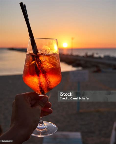 해변 바에서 술과 함께 스프리츠 전통 칵테일 한 잔을 들고 있는 알아볼 수 없는 여성 유럽 여름 음료 이탈리아 음료 라이프스타일