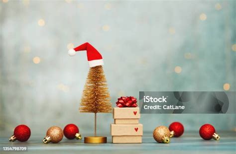 선물과 휴일 장식품이 쌓인 산타 모자를 쓰고 있는 골드 크리스마스 트리 현악 조명 및 복사 공간이 있는 파란색 배경 크리스마스에 대한 스톡 사진 및 기타 이미지 Istock