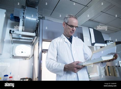 Male Meteorologist Reviewing Data File From Weather Station Laboratory