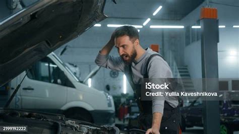 혼란스러운 충격 백인 남자 남자 자동차 정비사 남성 수리공 오픈 후드 보닛 주유소에서 고장난 자동차 마찰 머리 자동차 고장 사고
