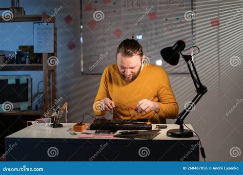 Man Testing Laptop Motherboard Using Multimeter Sitting On His Workplace Stock Photo Image Of