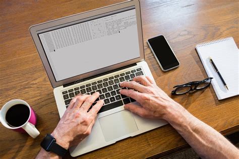 Hands Of Caucasian Male Programmer Siting At Desk Using Laptop With Coding On Screen Stock