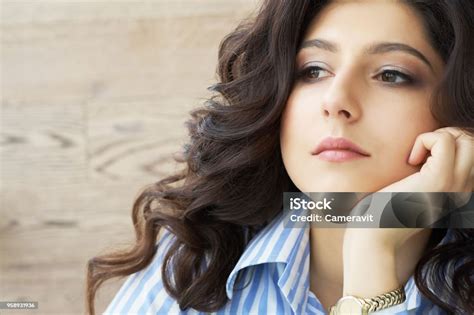 긴 곱슬 머리를 가진 소녀입니다 완벽 한 피부입니다 세련 된 럭셔리 뷰티 살롱에서 멋진 여자입니다 긴 곱슬 머리를 가진 소녀입니다 드레싱 룸에 창 근처에 앉아 머리를 가진