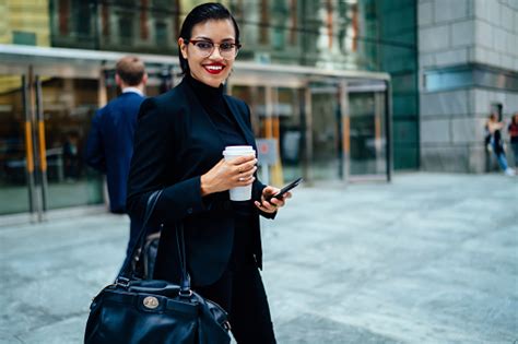 금융 지구의 도시 설정에 커피 휴식 동안 카메라에 미소 쾌활한 여성 집행 관리자의 절반 길이 초상화 우아한 옷과 안경에 성공적인 여성 소유자 거리에 대한 스톡 사진 및 기타