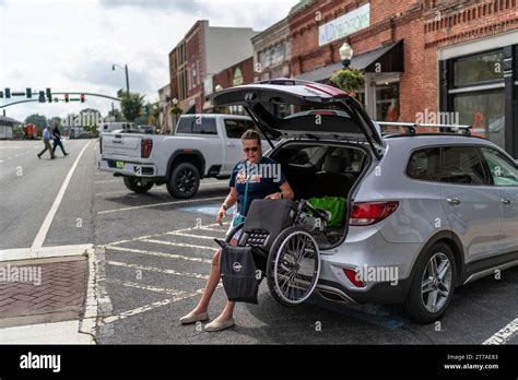 Janet Paulsen Removes Her Wheelchair Form The Trunk Of Her Car As She