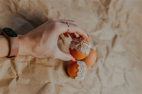 레이스와 밧줄로 크래프트 종이에 부활절 달걀을 장식합니다 크래프트 종이 배경에 세 부활절 달걀 여자 손 은 부활절 달걀을 들고 4월에 대한 스톡 사진 및 기타 이미지