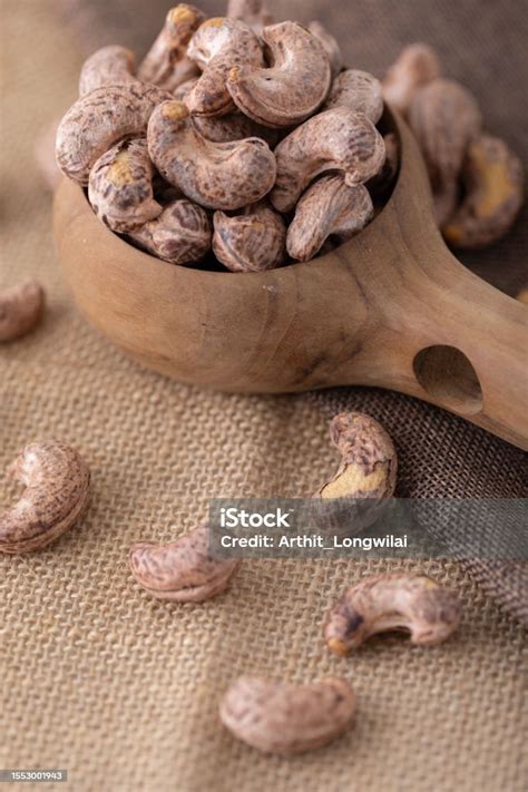 구운 캐슈넛과 반쪽을 테이블 위에 있는 나무 그릇에 담았다 매크로 스튜디오 샷 바구니에 담긴 수제 구운 소금에 절인 캐슈넛과 자루에 담긴 아침 식사 건강 식품 씨앗 스낵